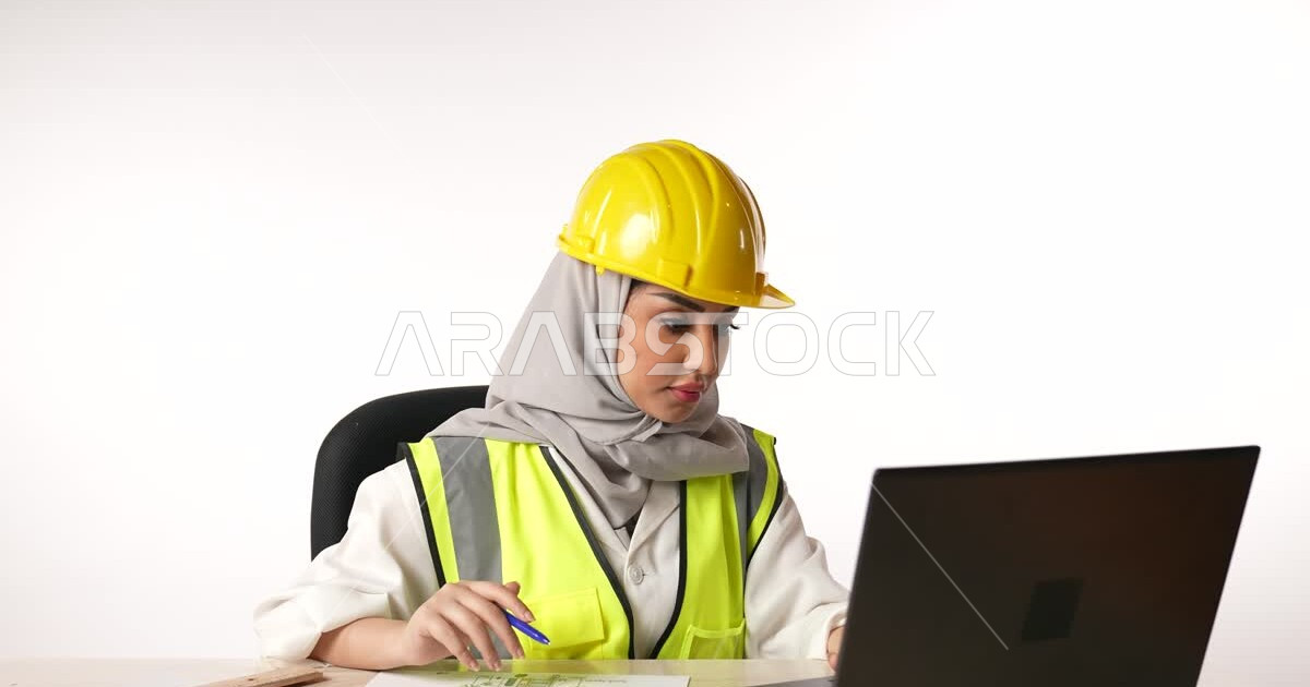Portrait of a veiled Saudi Arab Gulf engineer, wearing a helmet and ...