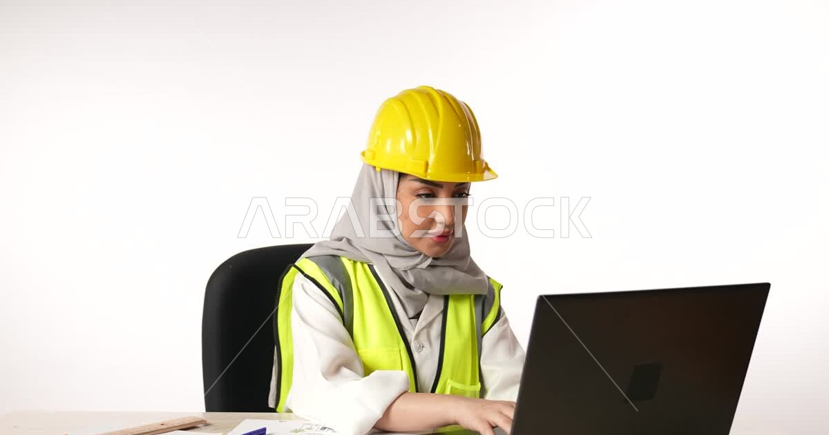 Portrait of a veiled Saudi Arab Gulf engineer, wearing a helmet and ...