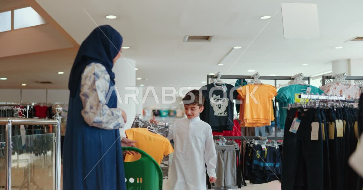 An Arab Saudi Gulf family shopping from clothing stores, enjoying ...