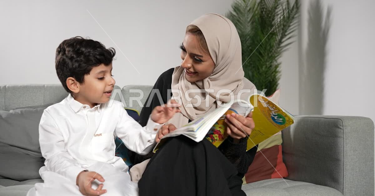 A Saudi Gulf Arab mother teaches her son at home, doing homework ...