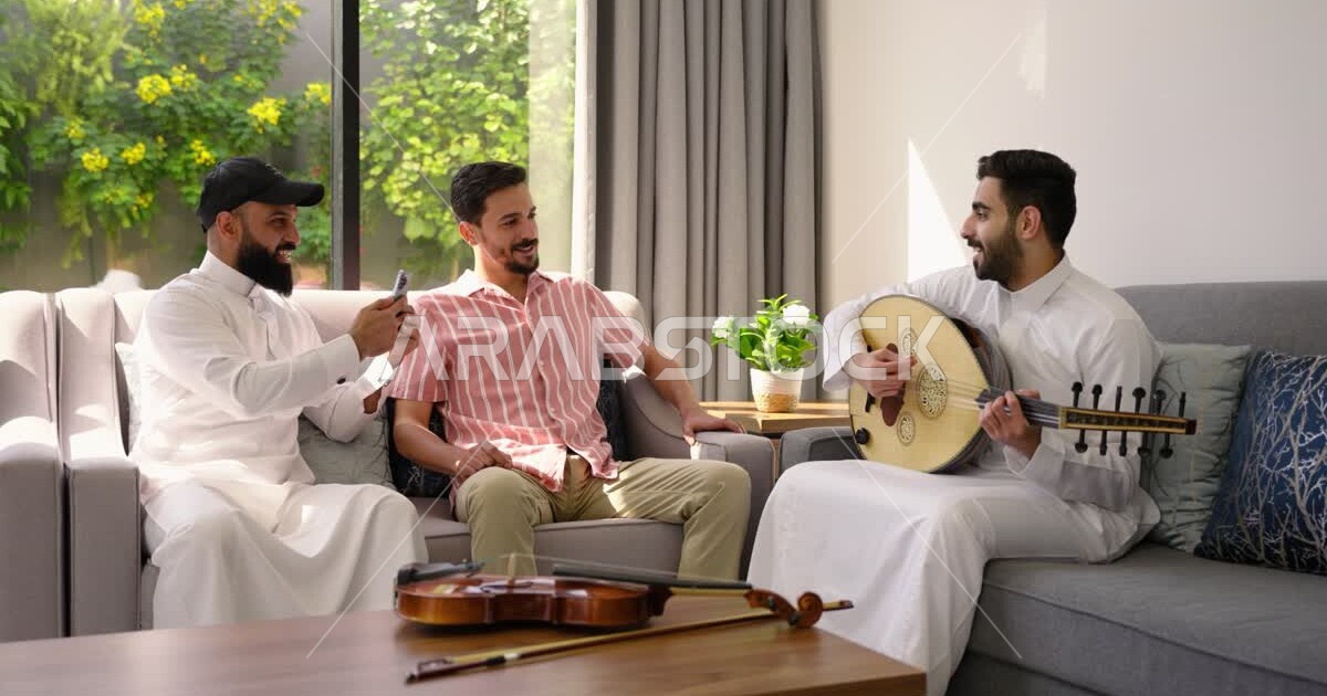 A group of Saudi Arab friends sitting at home, playing the violin and ...