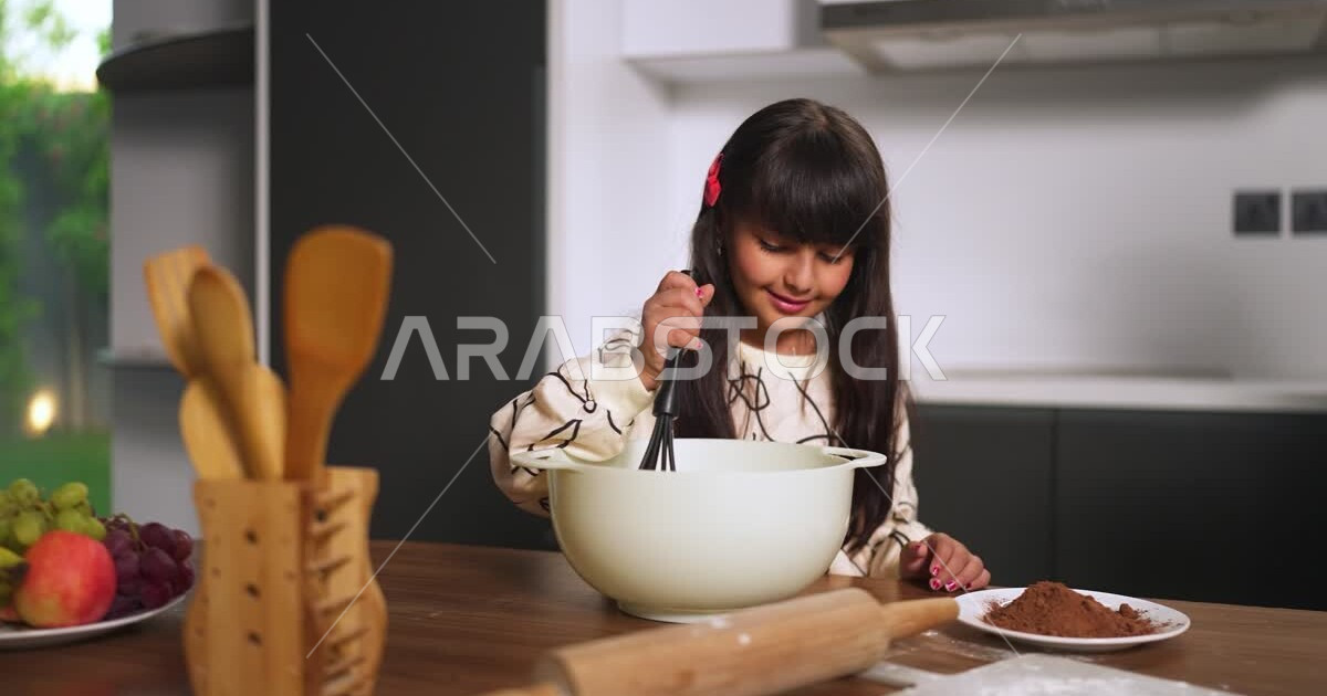 A Saudi Arabian Gulf mother participates with her daughter in preparing ...
