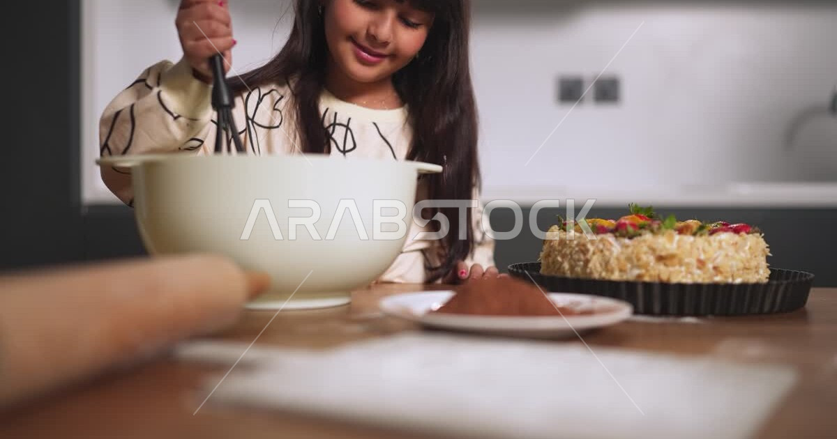 A Saudi Arabian Gulf mother participates with her daughter in preparing ...