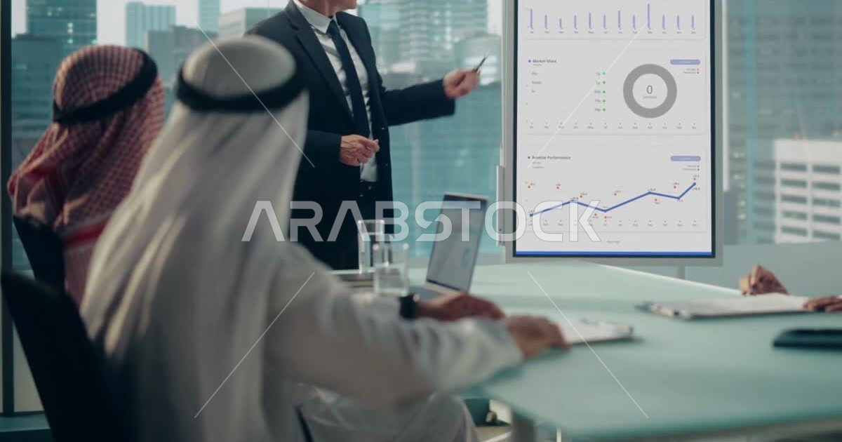 Meeting of Saudi Gulf Arab co-workers at their workplace, using a white ...