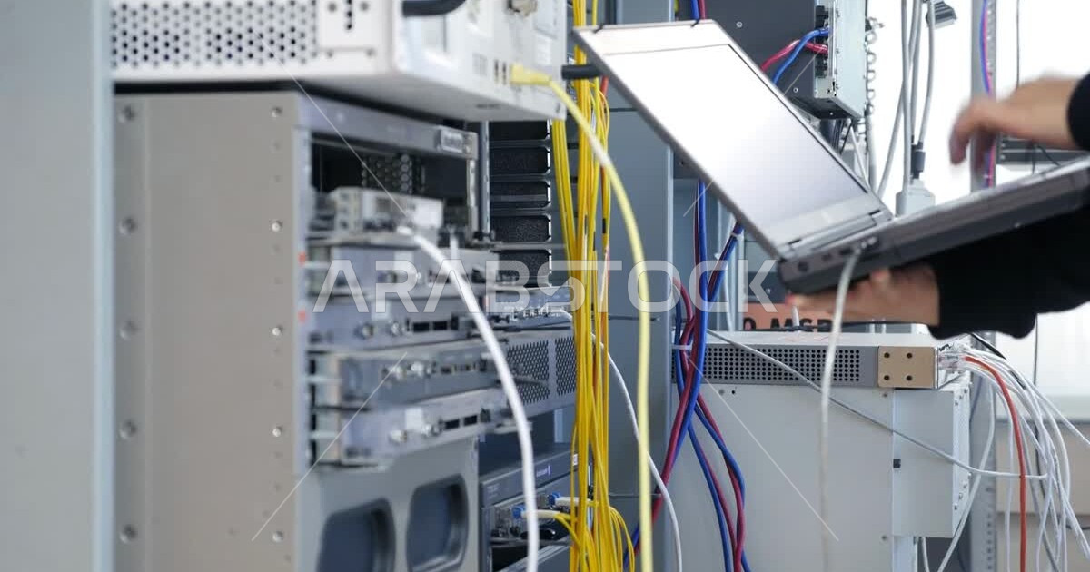 Network technician using a laptop to check the server station ...