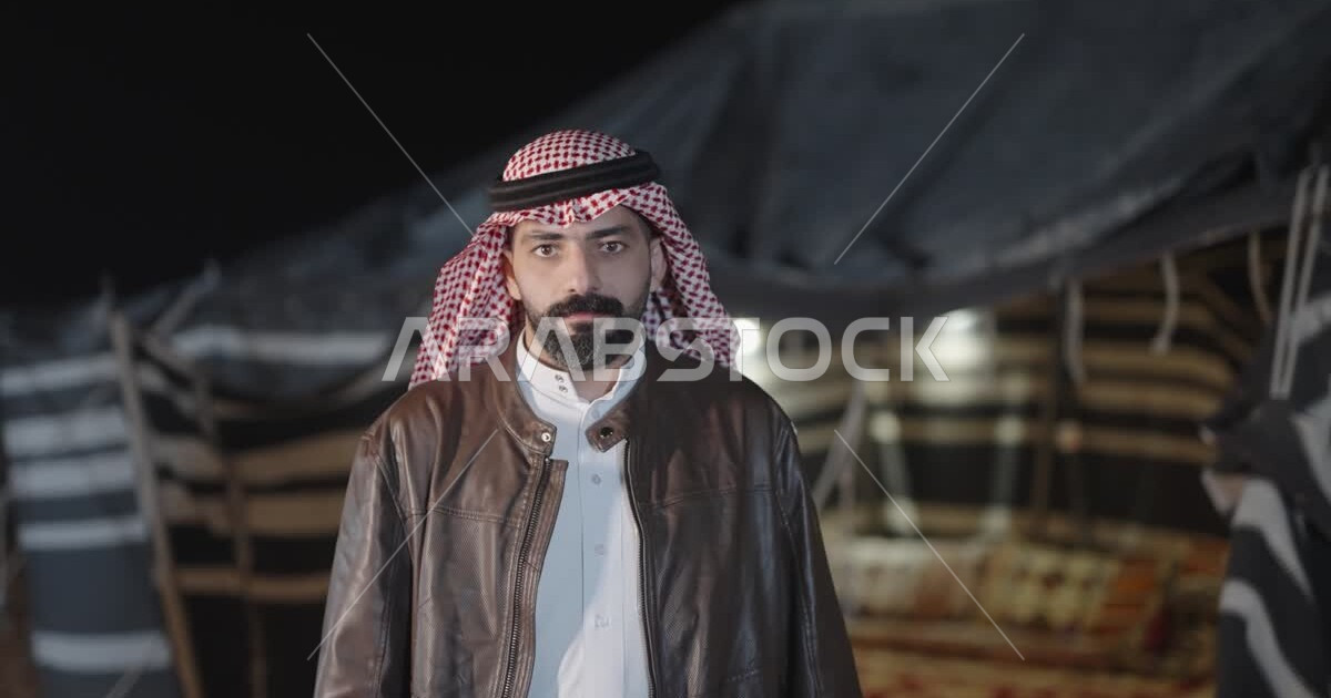 A Saudi Arabian Gulf man wearing warm winter clothes, camping places, a ...