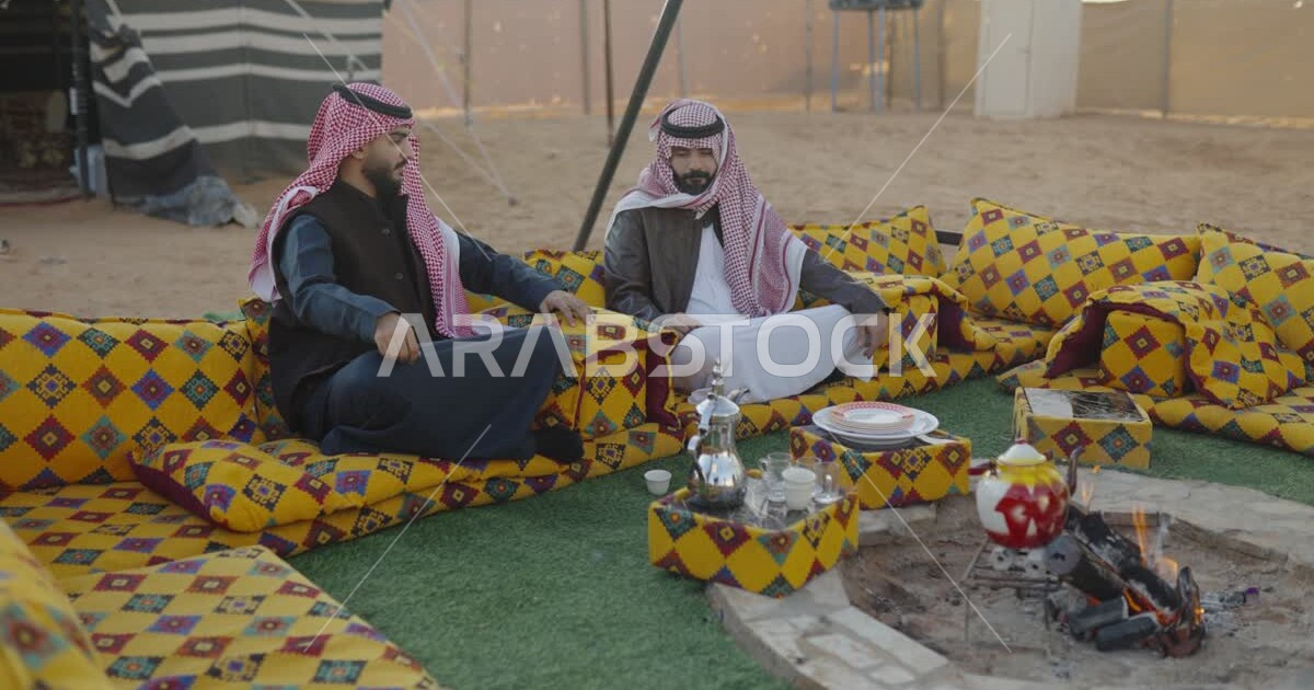 Two Saudi Arab Gulf men dressed in warm winter clothes, an Arabic ...