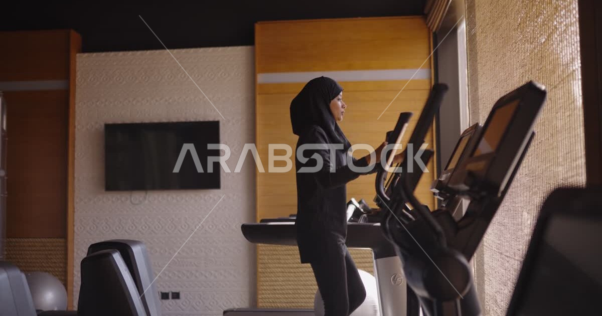 A veiled Saudi Gulf Arab woman wears sportswear, does exercise in the ...