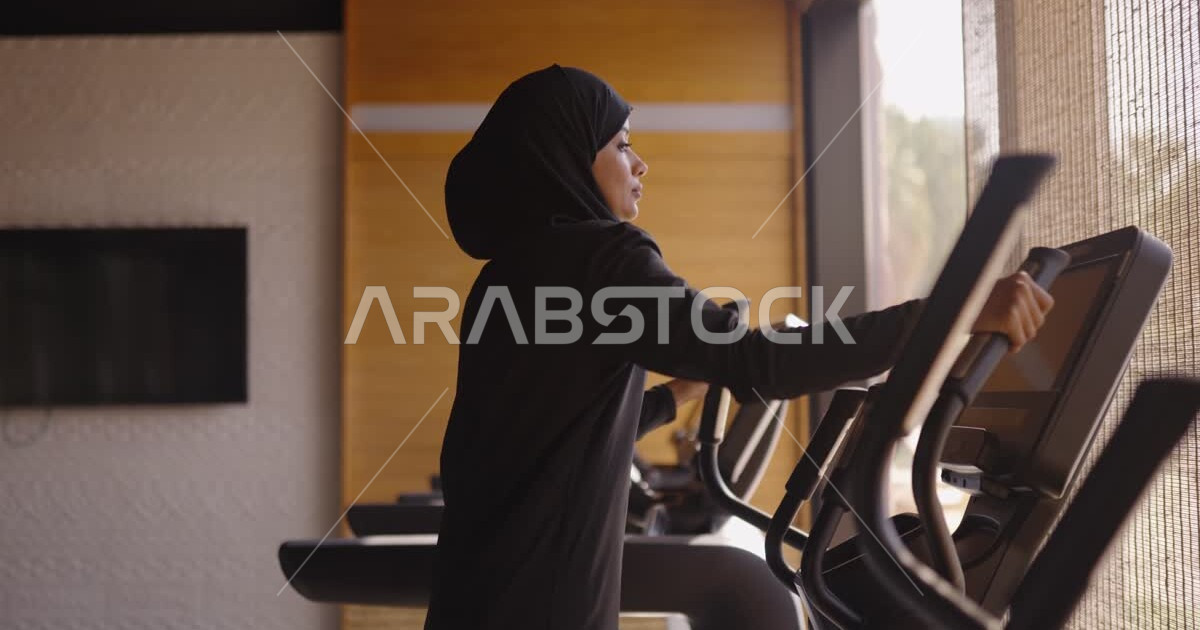 A veiled Saudi Gulf Arab woman wears sportswear, does exercise in the ...