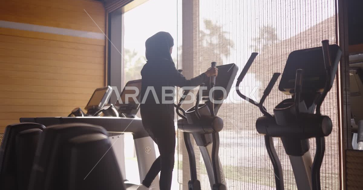A veiled Saudi Gulf Arab woman wears sportswear, does exercise in the ...
