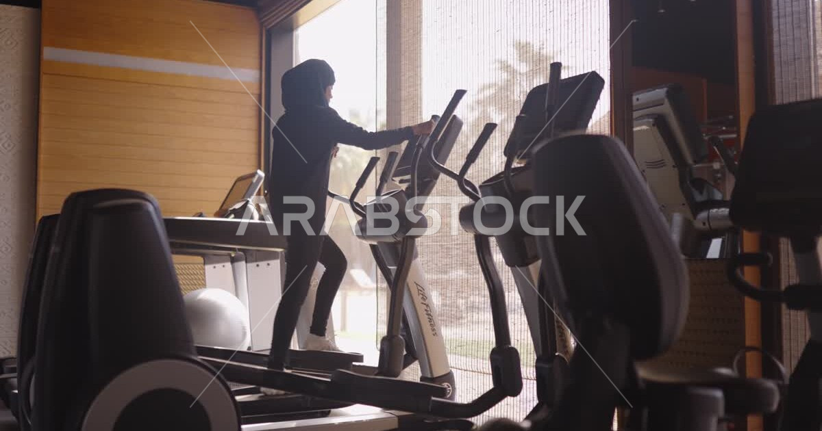 A veiled Saudi Gulf Arab woman wears sportswear, does exercise in the ...
