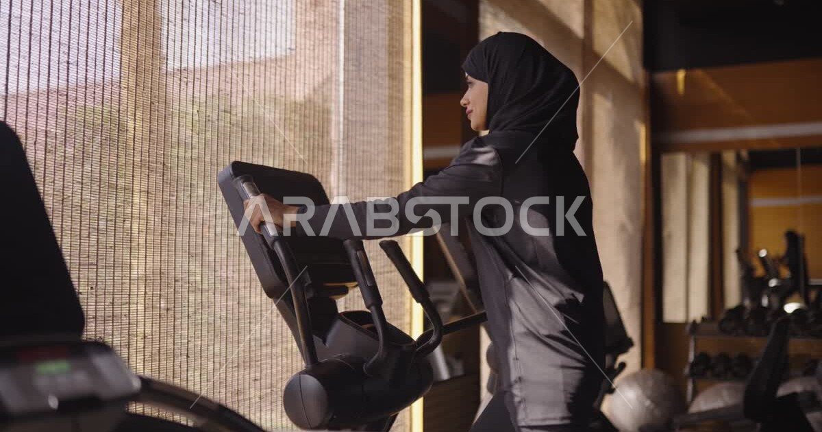 A veiled Saudi Gulf Arab woman wears sportswear, does exercise in the ...