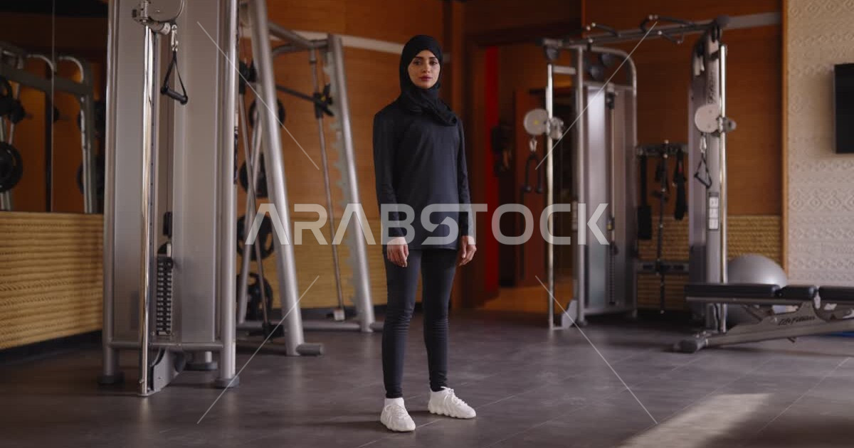 A veiled Saudi Arabian Gulf woman wearing sportswear in the gym ...