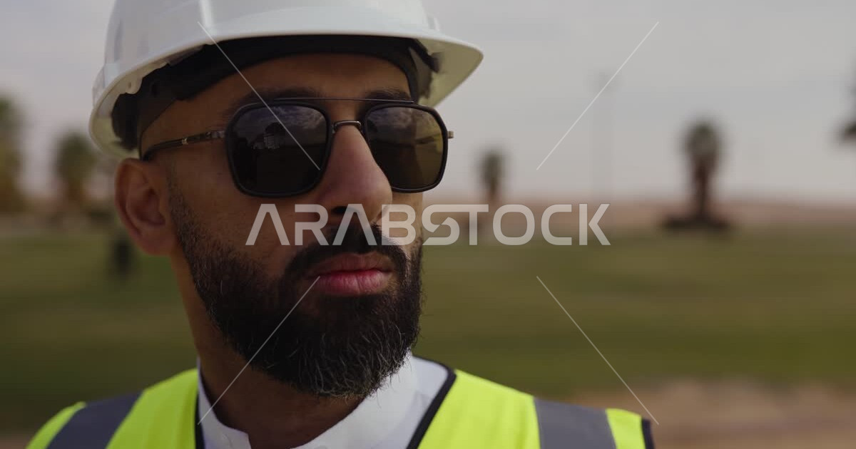 Close-up of a Saudi Arabian Gulf engineer, wearing sunglasses, a helmet ...