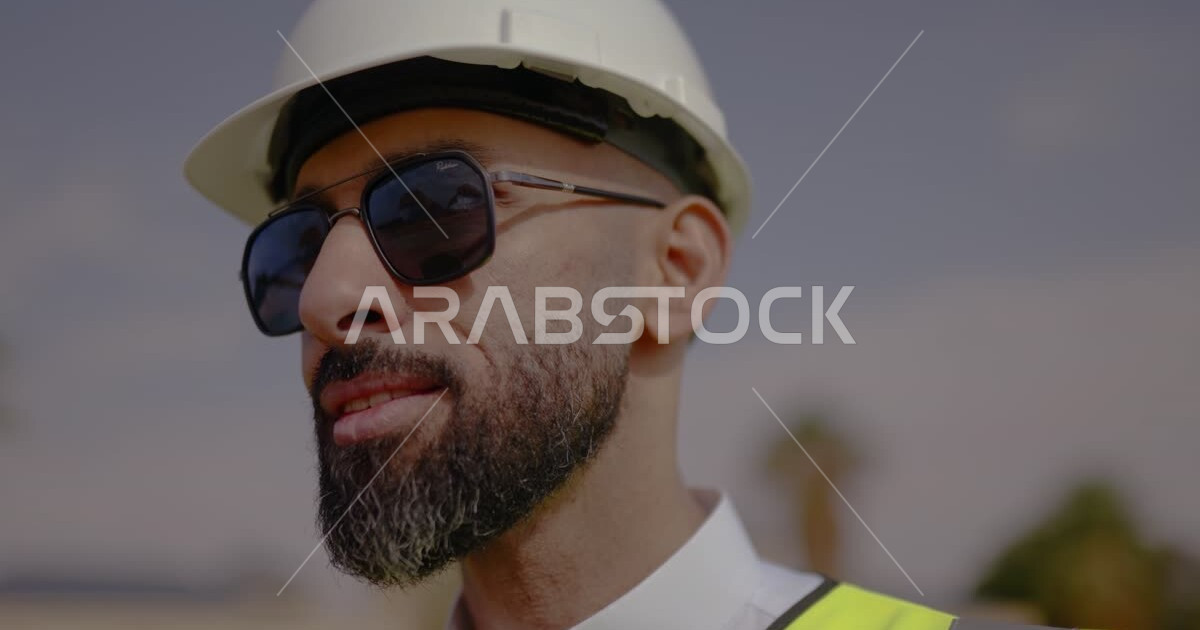 Close-up of a Saudi Arabian Gulf engineer, wearing sunglasses, a helmet ...