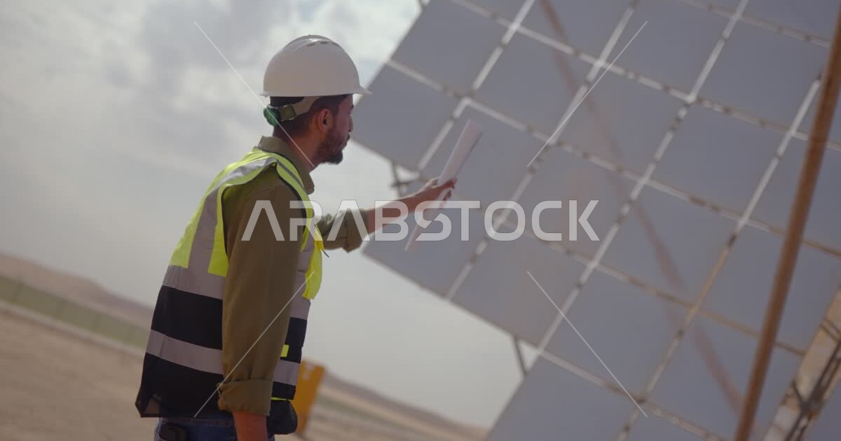 An Arab Gulf Saudi energy engineer holding a map in his hand and ...