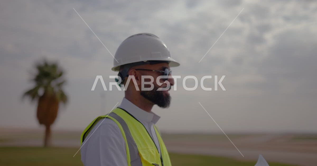 An Arab Gulf Saudi engineer, wearing sunglasses, a helmet and a work ...