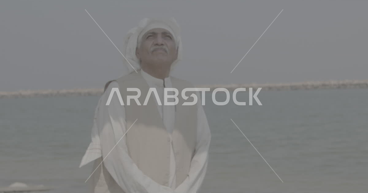 Close-up of an elderly Arab Gulf man wearing a galabia, a shower, a man ...