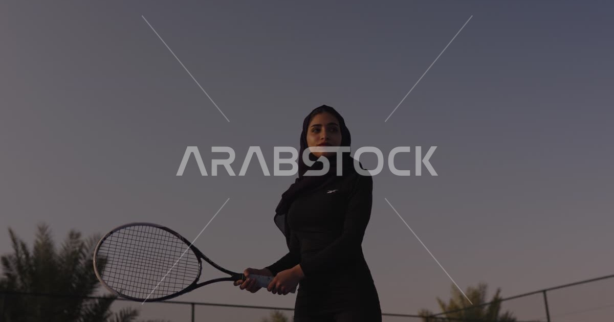 A Saudi Arab Gulf woman playing tennis, playing tennis in public courts ...