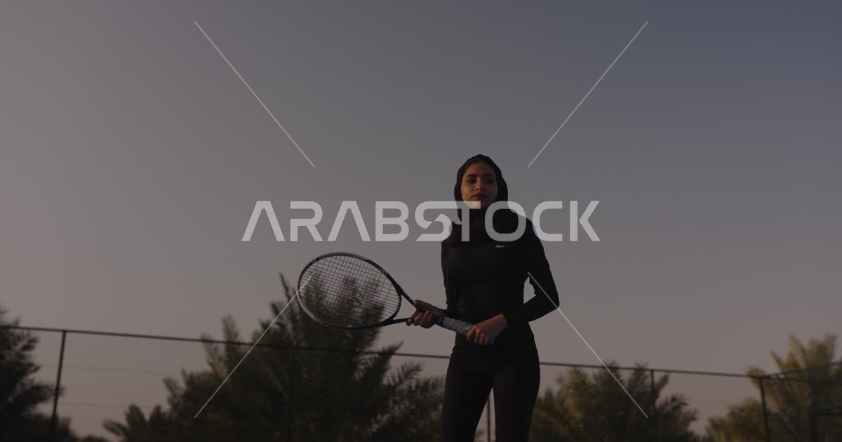 A Saudi Arab Gulf woman playing tennis, playing tennis in public courts ...