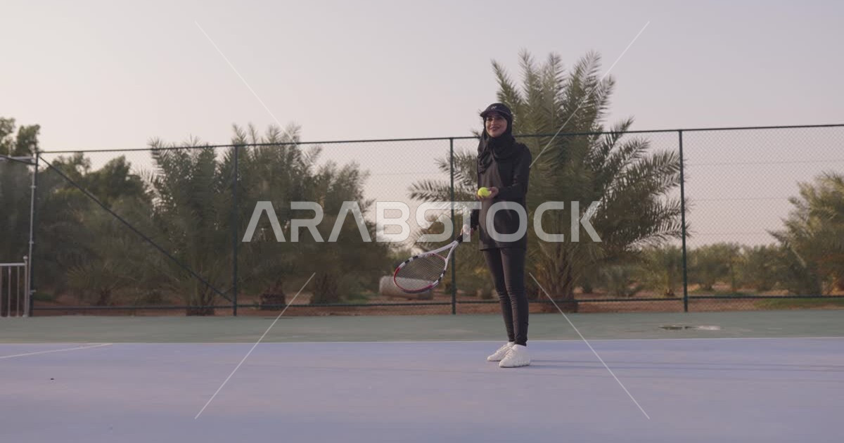 A Saudi Arab Gulf woman playing tennis, playing tennis in public courts ...