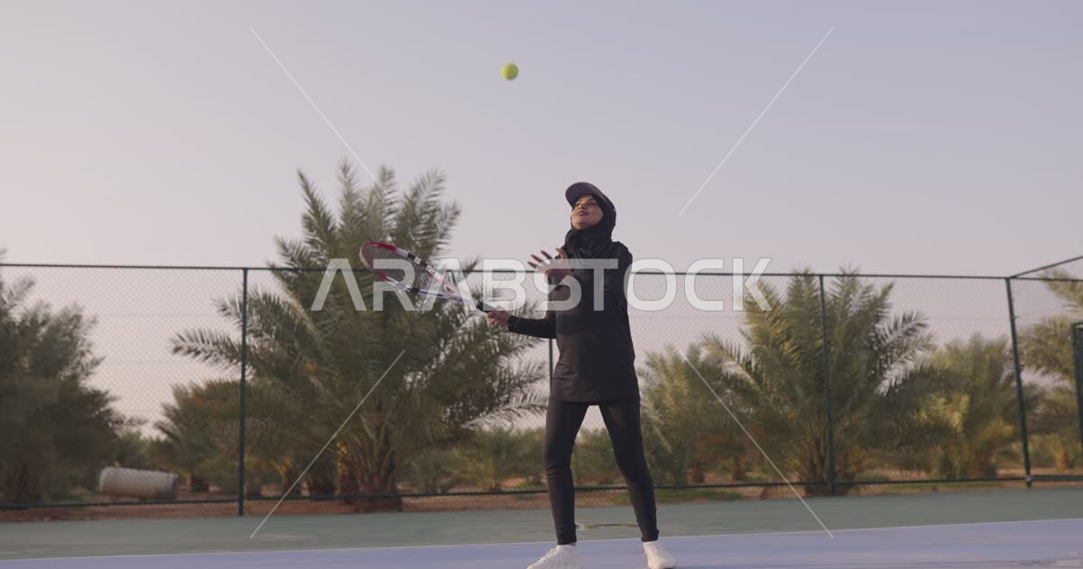 A Saudi Arab Gulf woman playing tennis, playing tennis in public courts ...