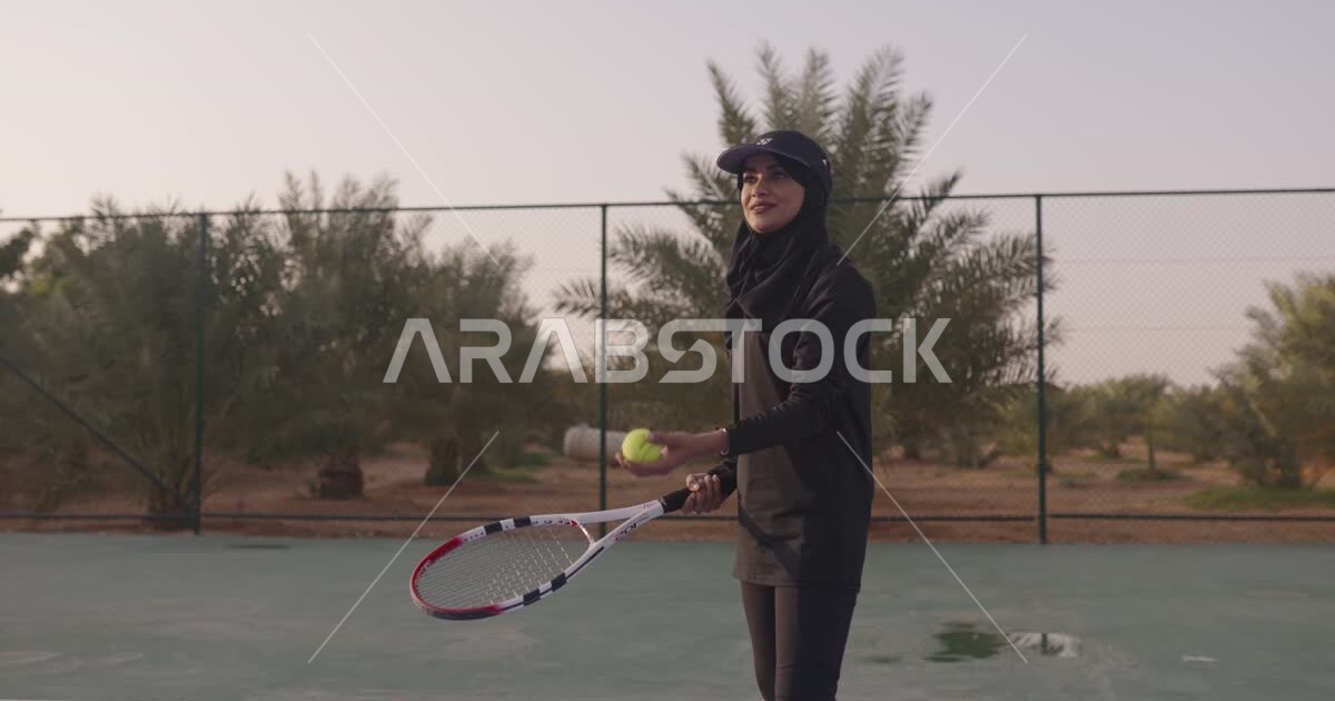 A Saudi Arab Gulf woman playing tennis, playing tennis in public courts ...