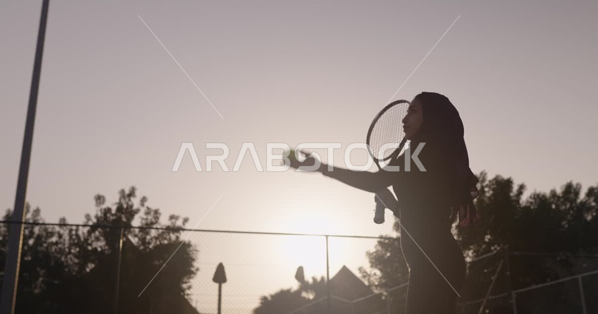 A Saudi Arab Gulf woman playing tennis, playing tennis in public courts ...