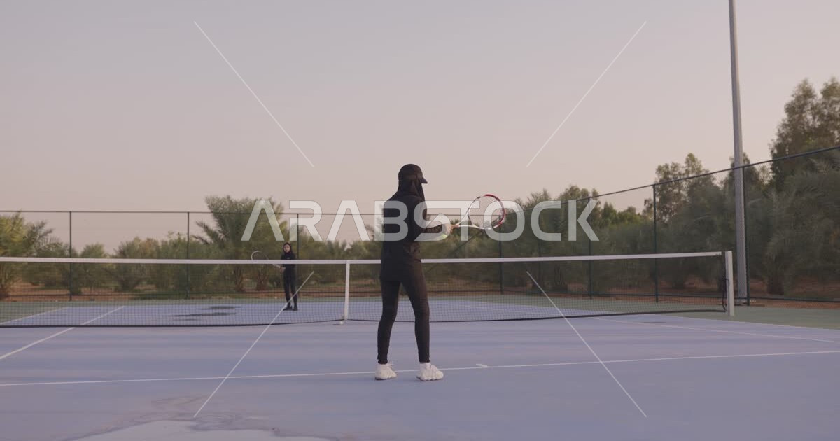 Two Saudi Arabian Gulf girls playing tennis, playing tennis in public ...