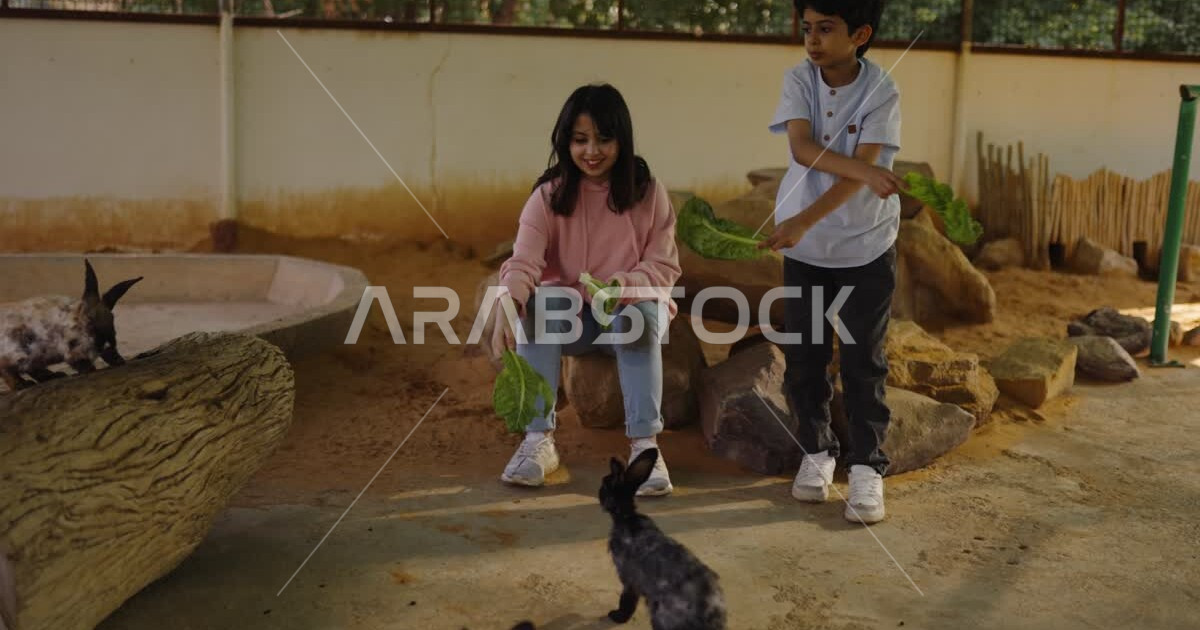 A Saudi Gulf Arab boy and girl in the zoo, safari in Riyadh, watching ...