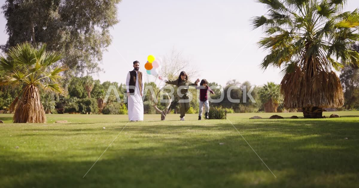 A Saudi Arabian Gulf man spends fun times with his family in a park in ...