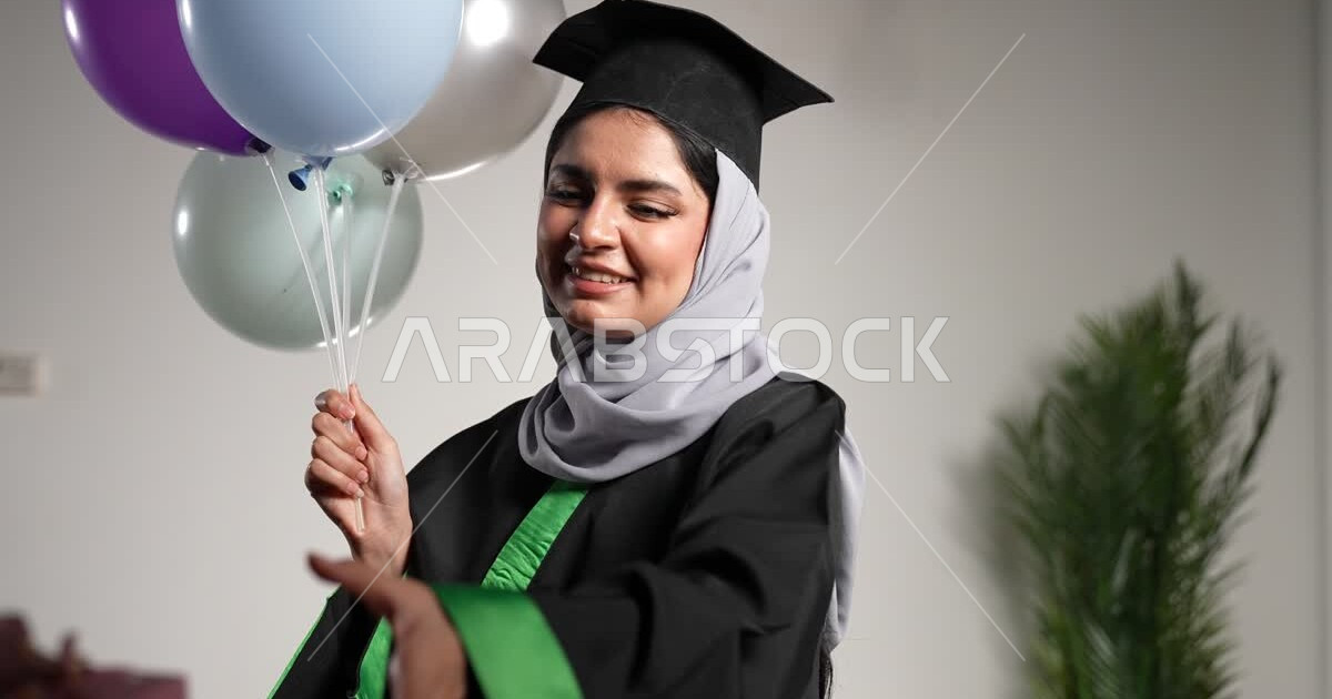 Smiling Saudi Gulf Arab woman, wearing abaya and graduation hat ...