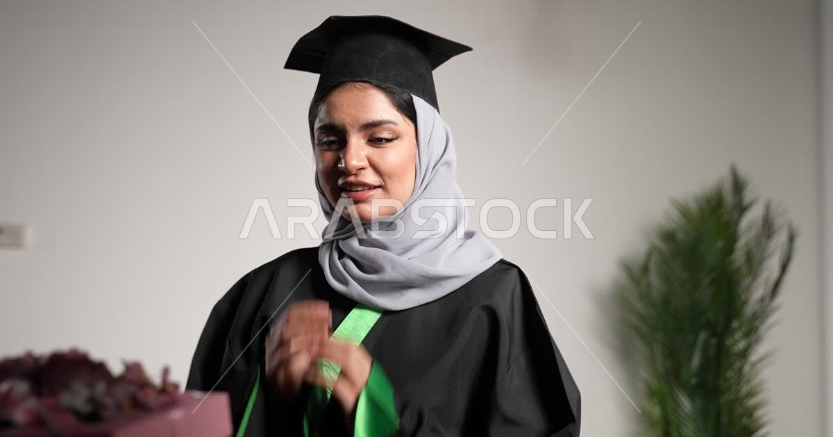 Smiling Saudi Arab Gulf woman, wearing abaya and graduation hat ...