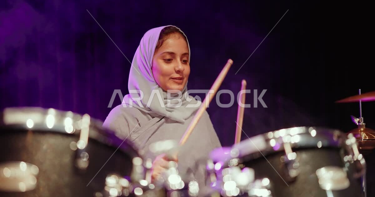A Saudi Arab Gulf woman playing drums, spending pleasant times ...