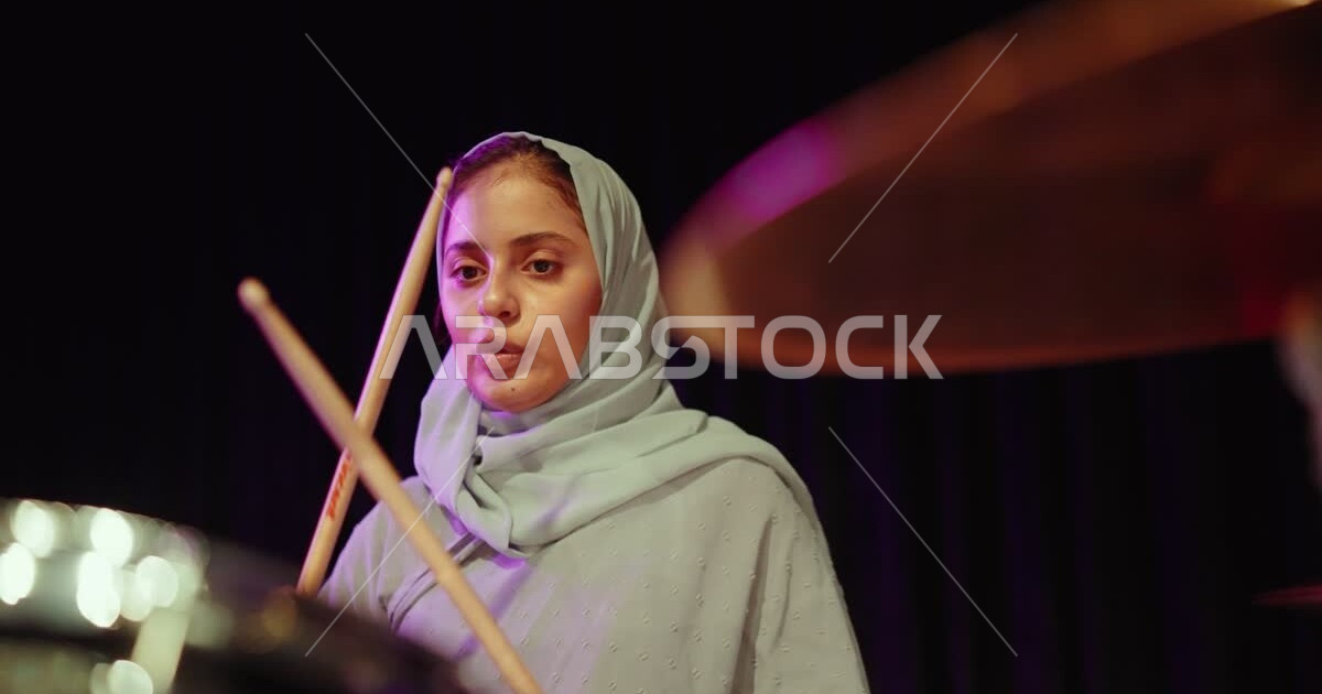A Saudi Arab Gulf woman playing drums, spending pleasant times ...
