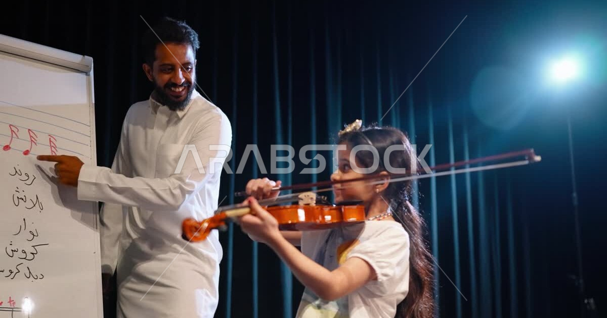 A Saudi Arabian Gulf man giving music lessons, a Saudi Arab girl ...