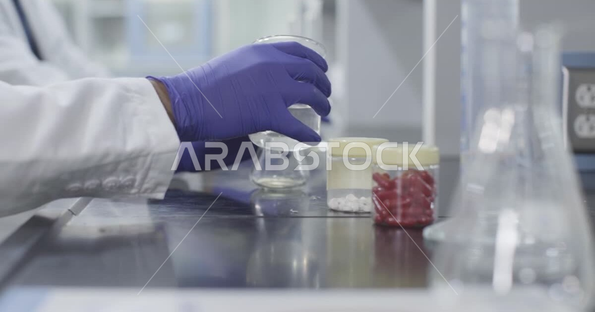 Gulf laboratory doctor wearing medical gloves, using glass tubes to ...
