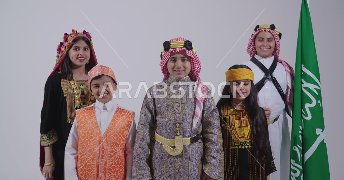 Chroma, a group of Saudi Arab children, next to the Saudi flag, wearing ...