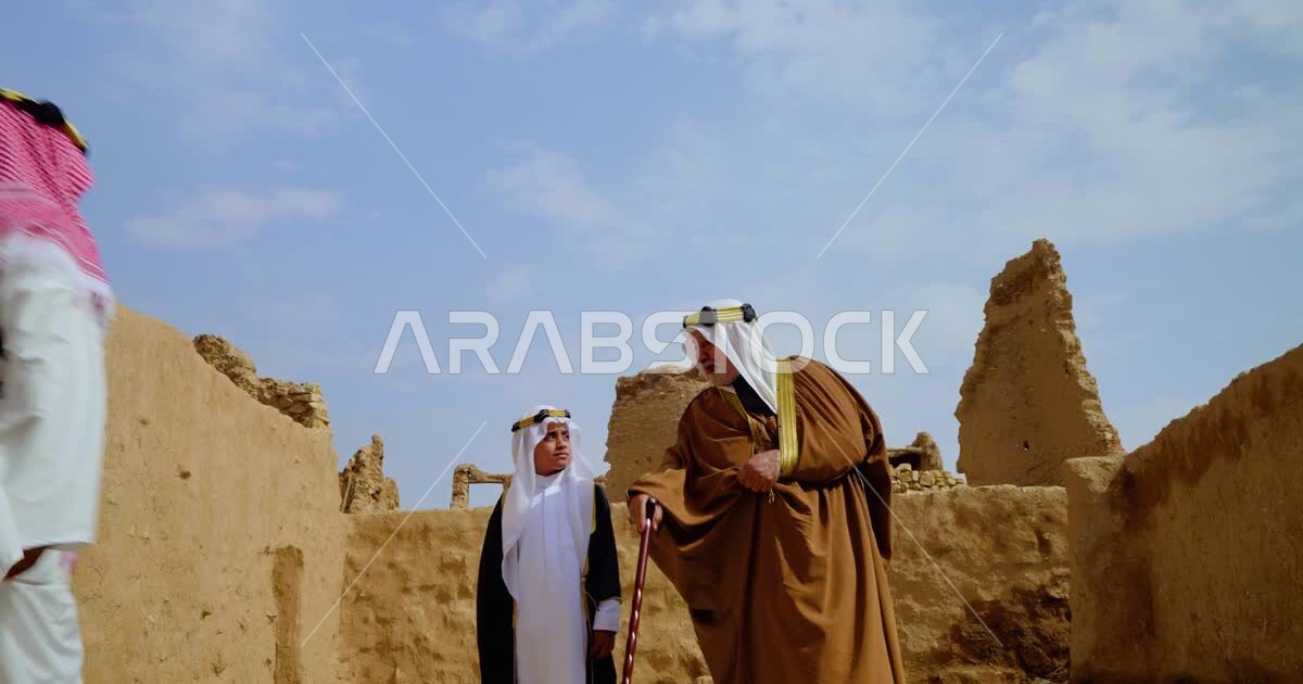 An elderly man and a boy, two Saudi Arabs from the Gulf, dressed in the ...