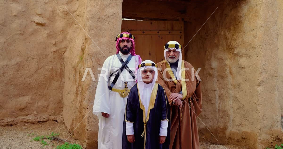 Two men and boys, Saudi Arabs from the Gulf, dressed in the traditional ...