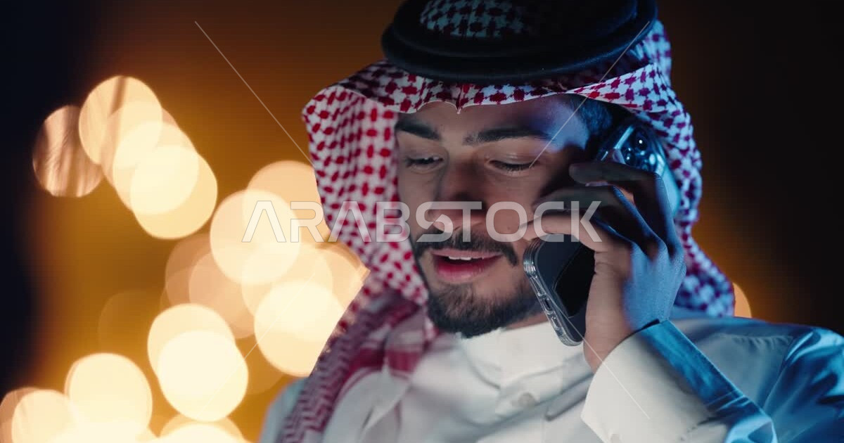 A Saudi Arabian Gulf man dressed in traditional Saudi dress making a ...