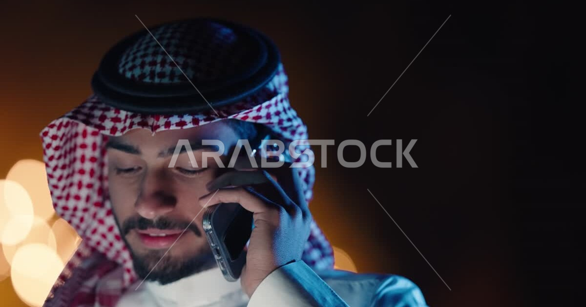 A Saudi Arabian Gulf man dressed in traditional Saudi dress making a ...