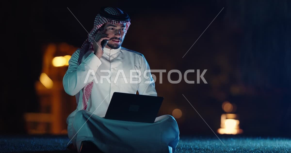 A Saudi Arabian Gulf man dressed in traditional Saudi dress making a ...