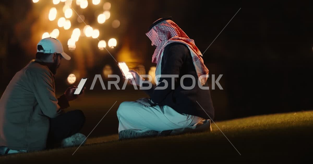 Photography from the back of two Saudi Arabian Gulf men sitting on the ...