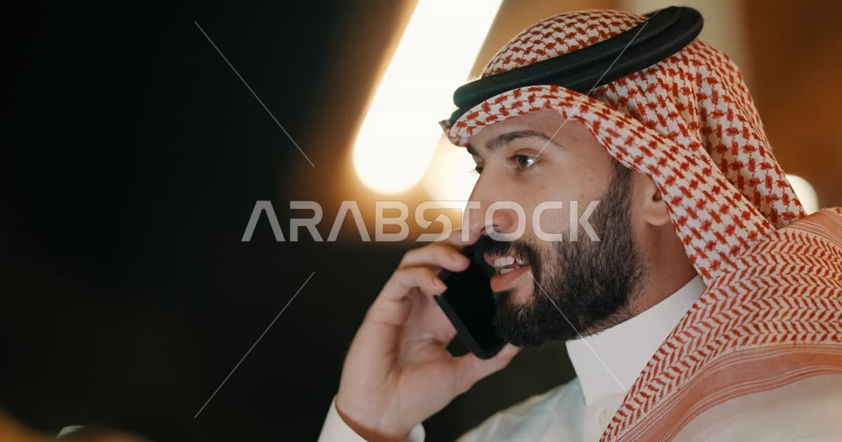 Close-up of a Saudi Arabian Gulf man, making a phone call using a ...