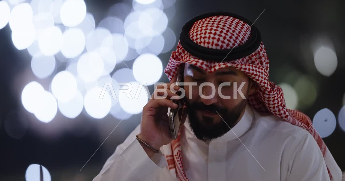 Close-up of a Saudi Arabian Gulf man, making a phone call using a ...