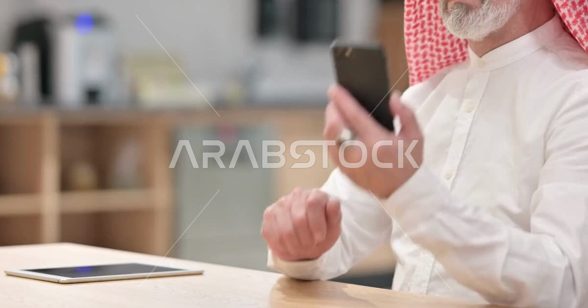 A Saudi Arab Gulf businessman using a mobile phone, making a phone call ...