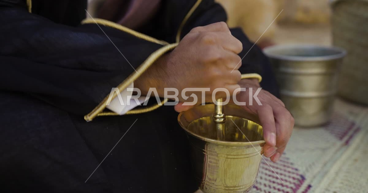 A Saudi Arabian Gulf man using an old copper mill, works and ...