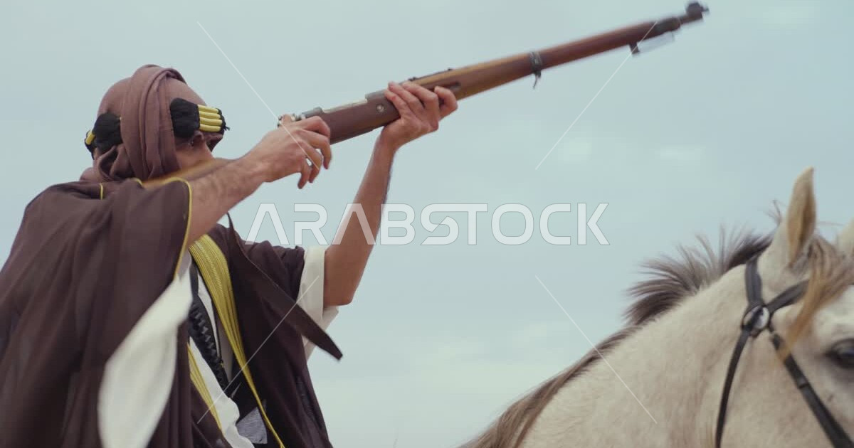A Saudi Arab Gulf knight riding a horse in the desert and shooting ...