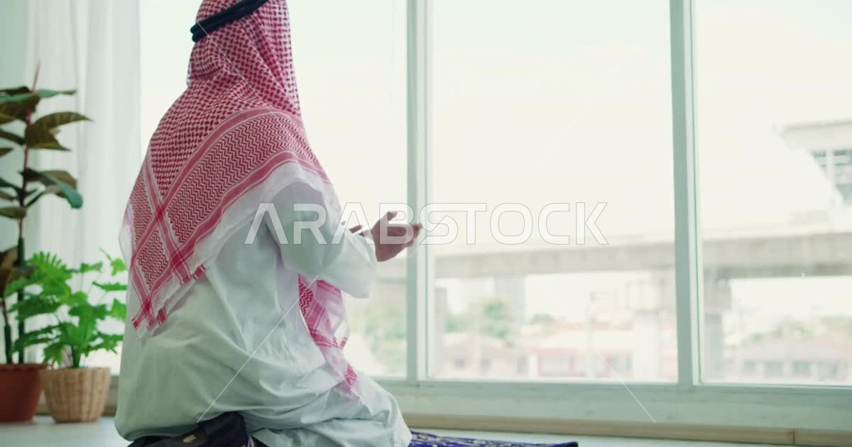 An Arab Gulf Saudi Muslim man raises his hand high, supplication to God ...